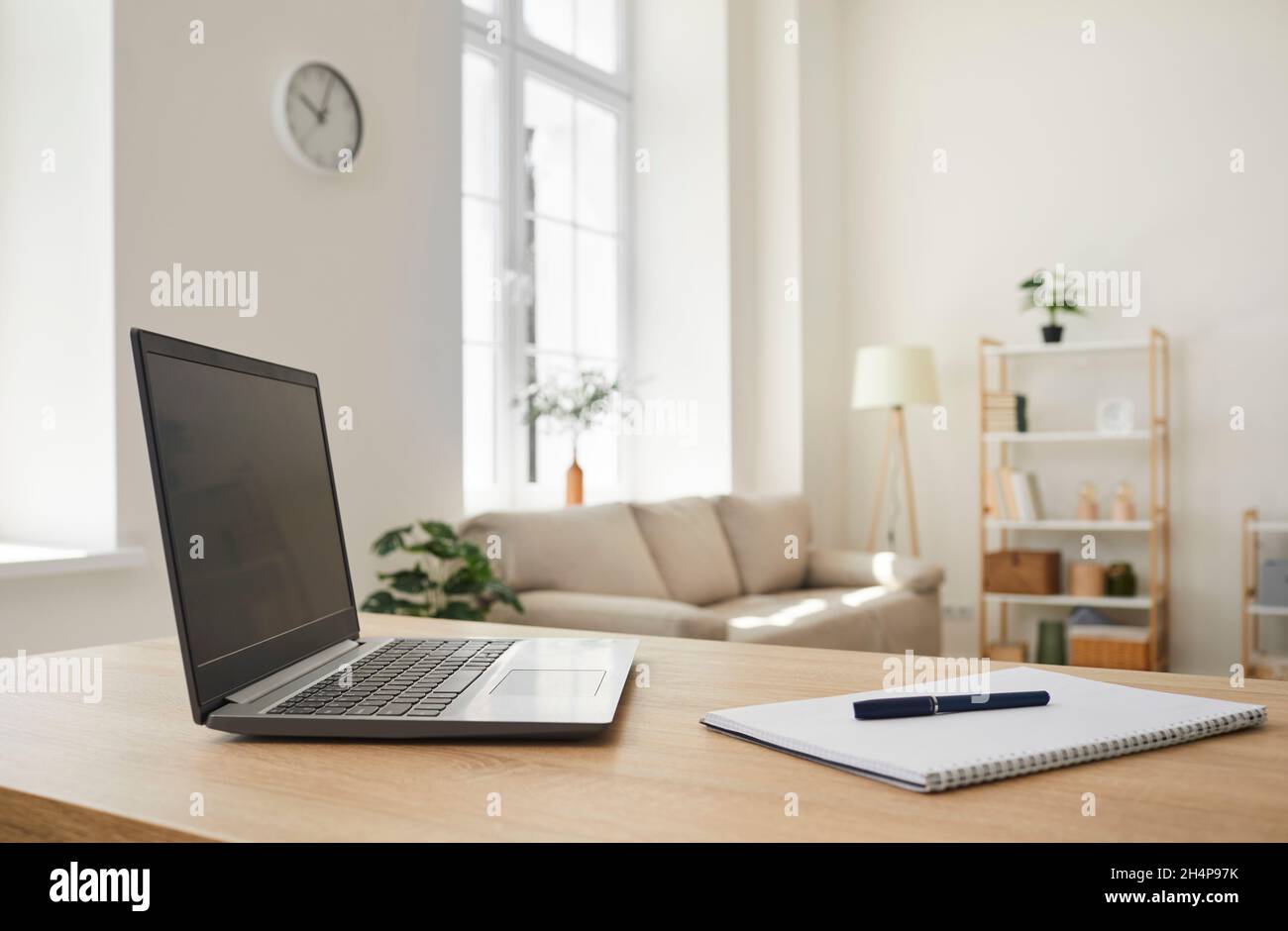 Laptop computer and notebook with pen placed on working desk in empty ...