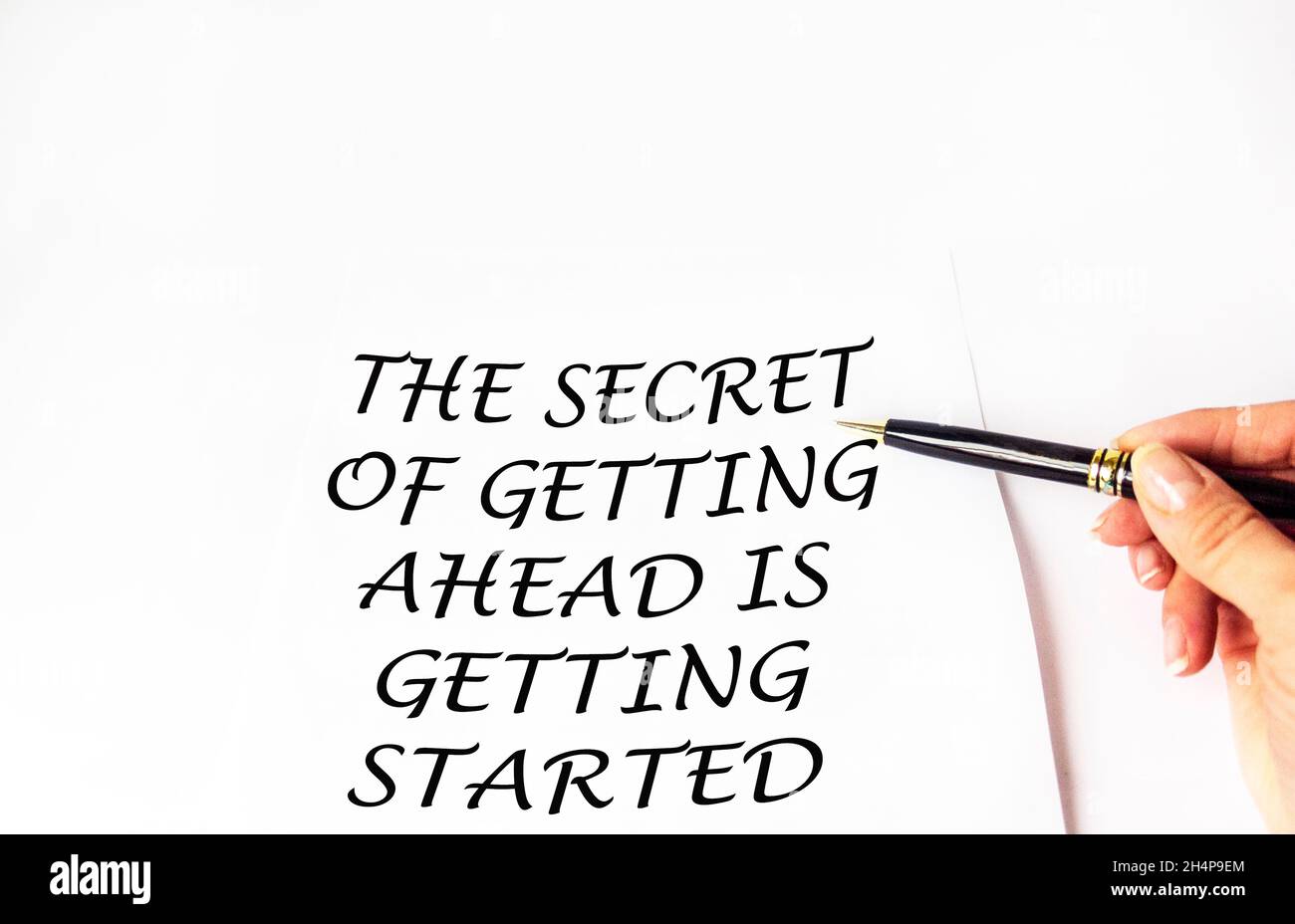 A woman's hand writes an inspirational quote - the secret to success is ...