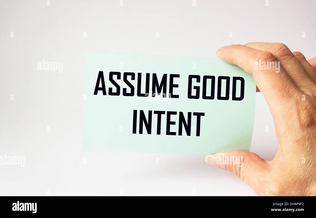 Assume good intent, card is held by female hand on white background ...