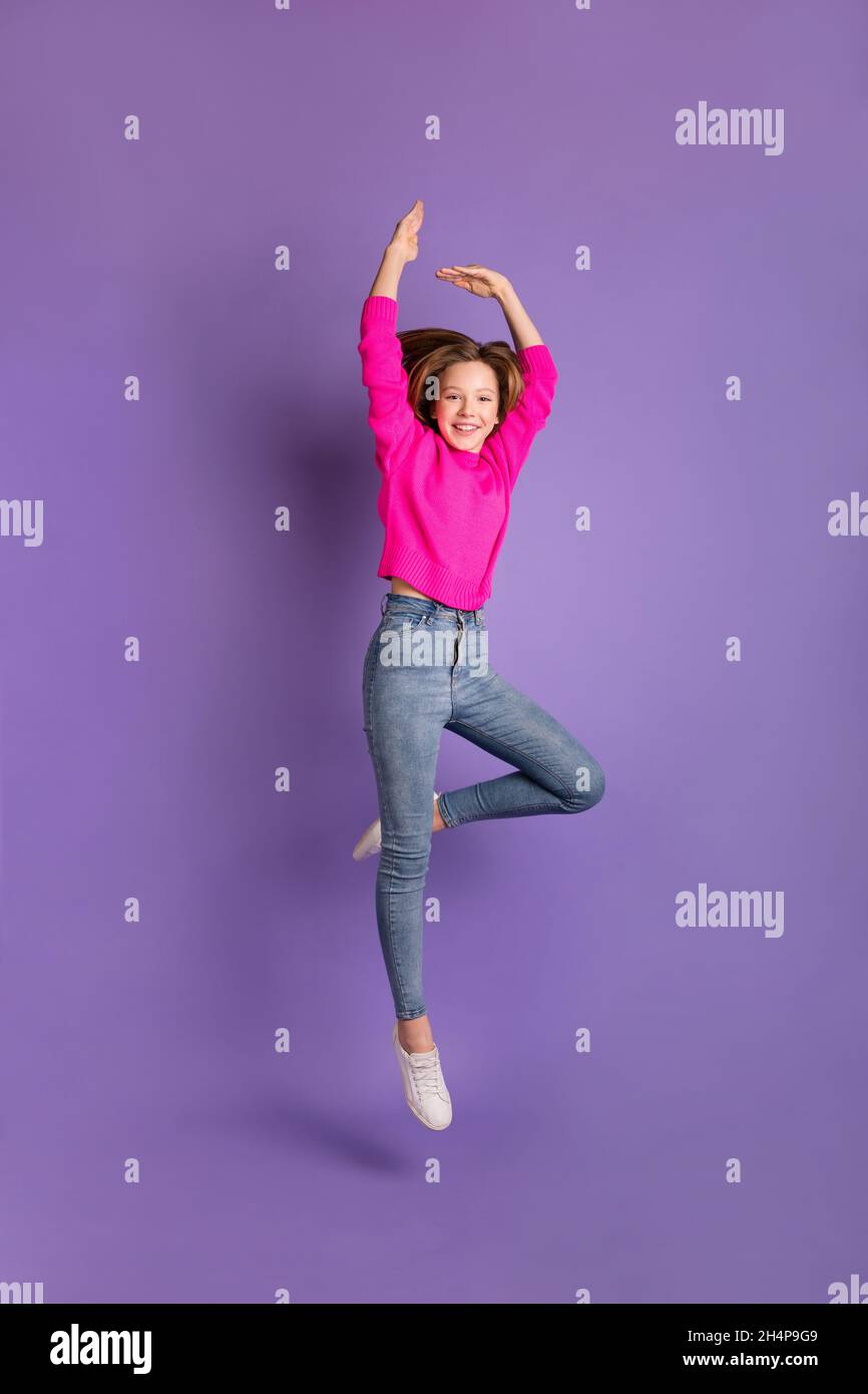 Vertical full size photo of cute cheerful nice little girl jump up air ...