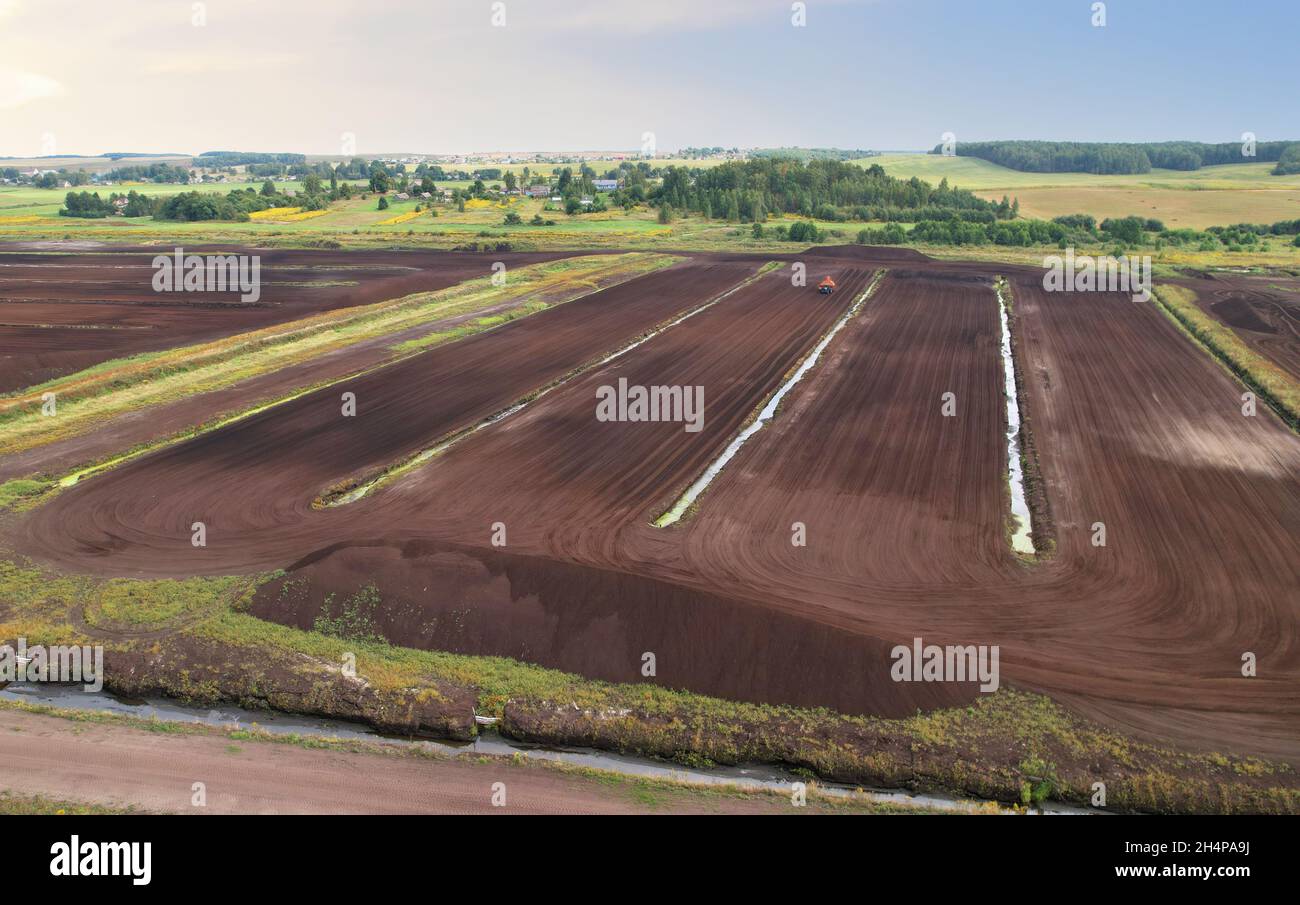 Peat extraction site. Harvester at collecting peat on peatlands. Mining ...