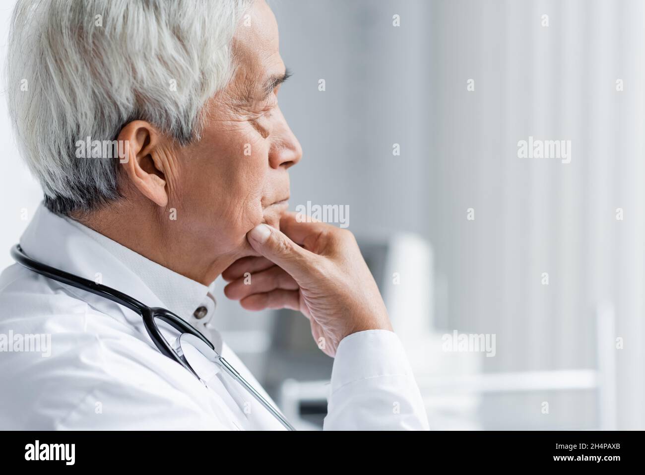 Side view of senior asian doctor looking away in clinic Stock Photo - Alamy