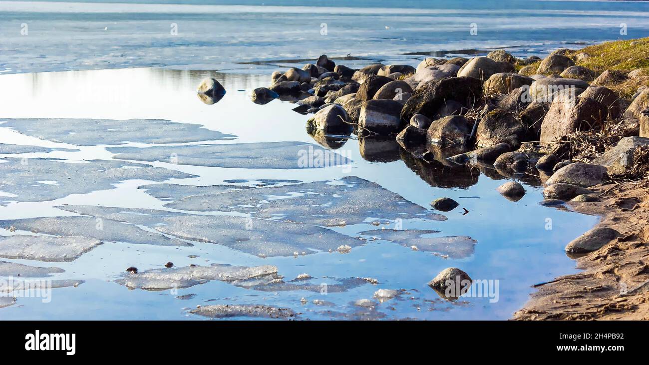 Early spring on the bank with the stones of the melting river Stock ...