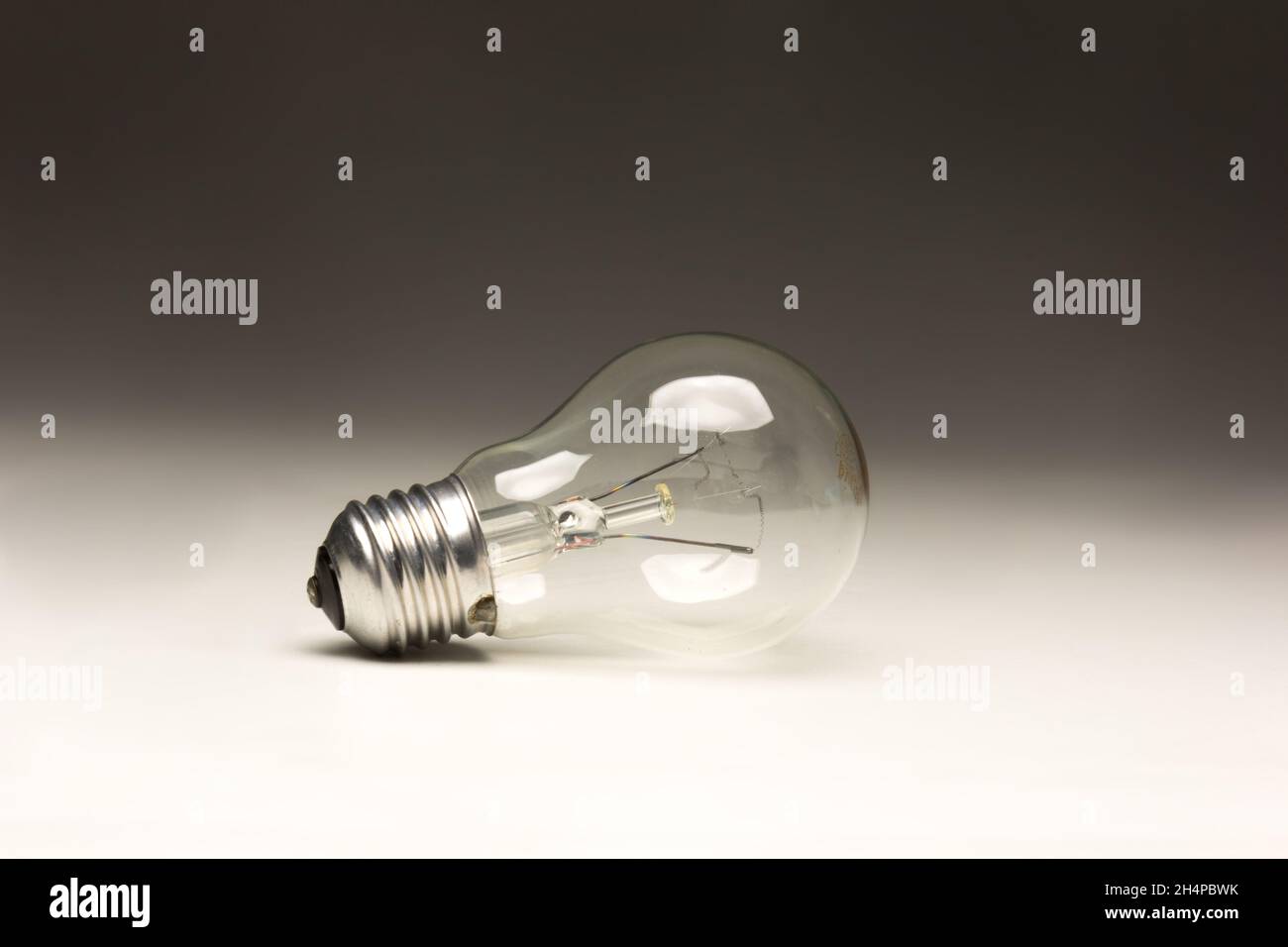 Clear glass incandescent filament bulb, analog technology Stock Photo ...