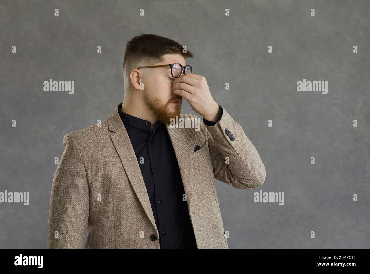 Tired man rubbing his strained eyes after long working day full of ...