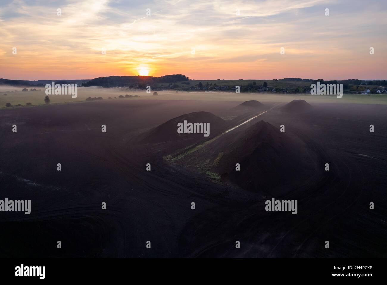 Peat extraction site in fog on sunset. Collecting peat on peatlands ...