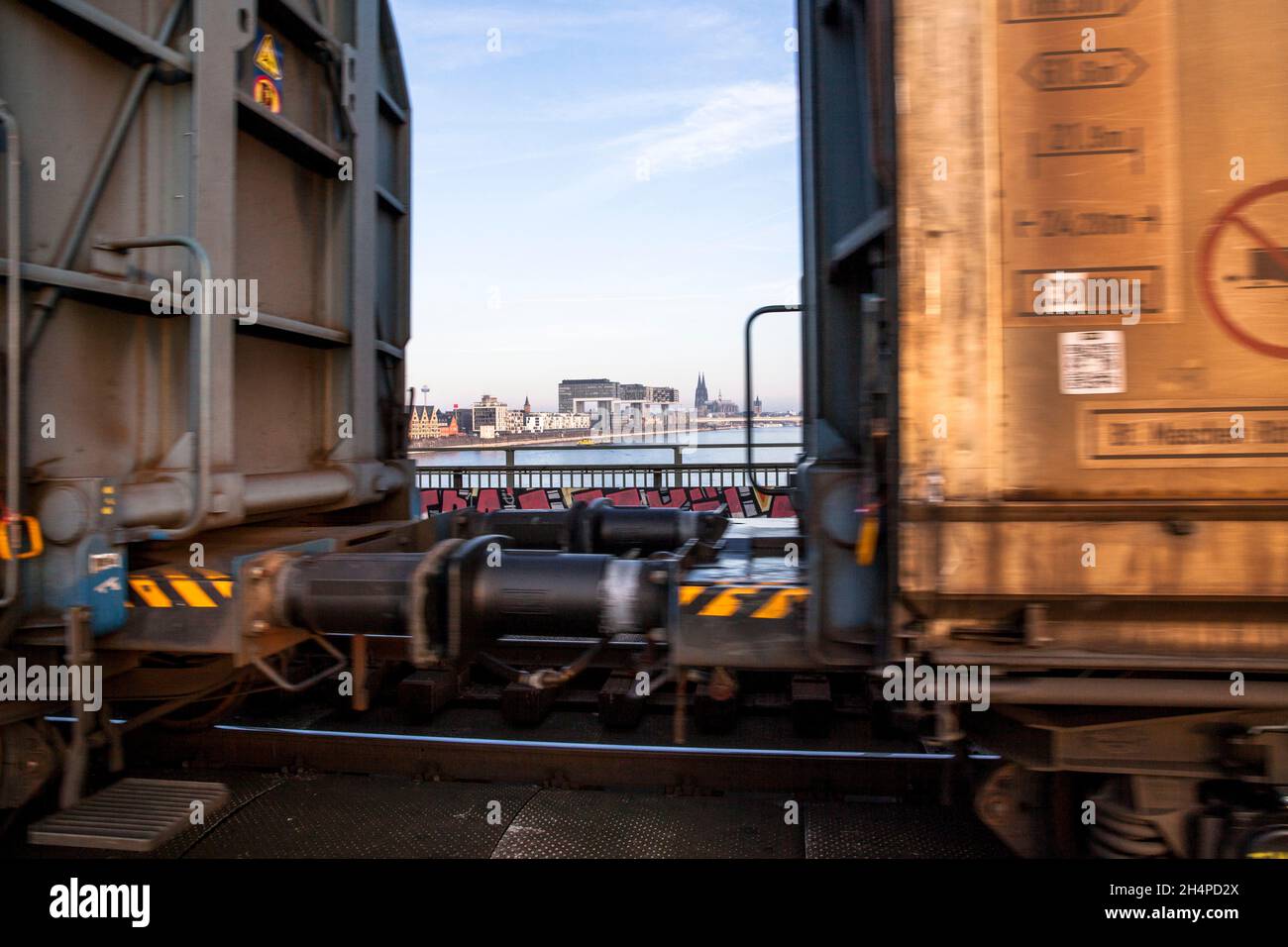 view through the gap between two wagons of a passing freight train on ...