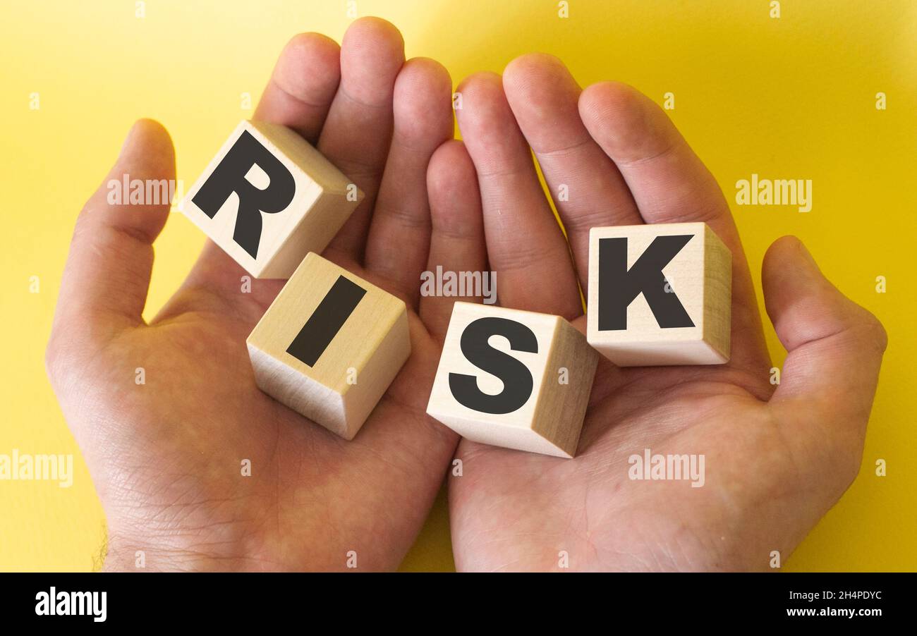 Closeup male hand with wooden blocks Risk text Risk management concept ...