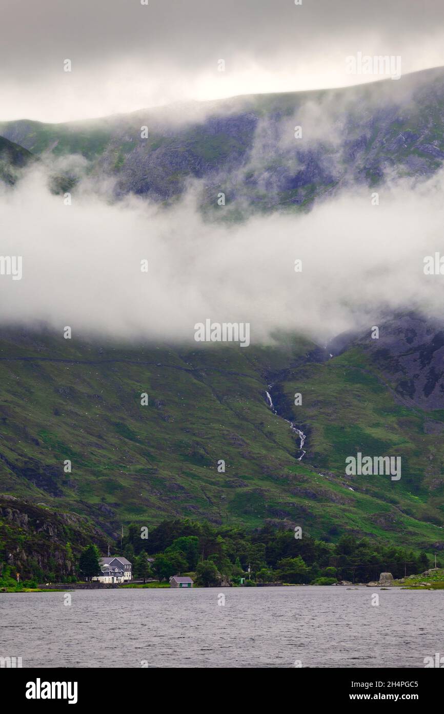 Hanging clouds over the mountains and Ogwen boathouse at Llyn Ogwen ...