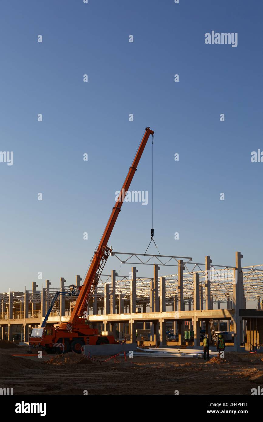 Crane build steel construction. Workers at industrial site Stock Photo ...