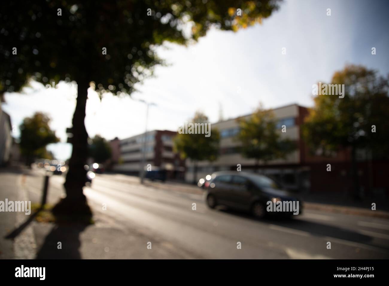 Blurred view of a car driving on the road by short buildings Stock ...