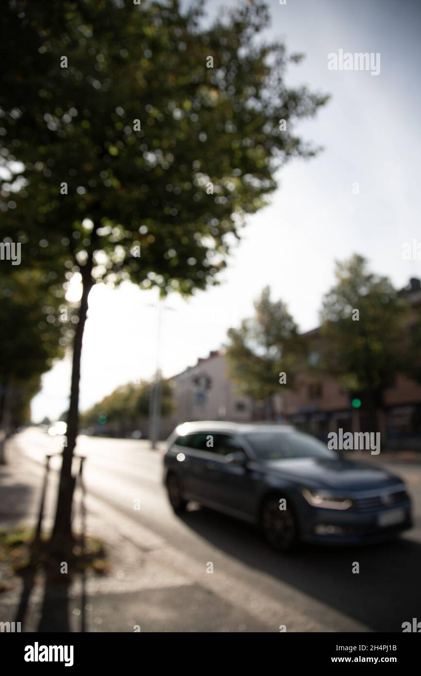 Blurred view of a car driving on the road by short buildings Stock ...