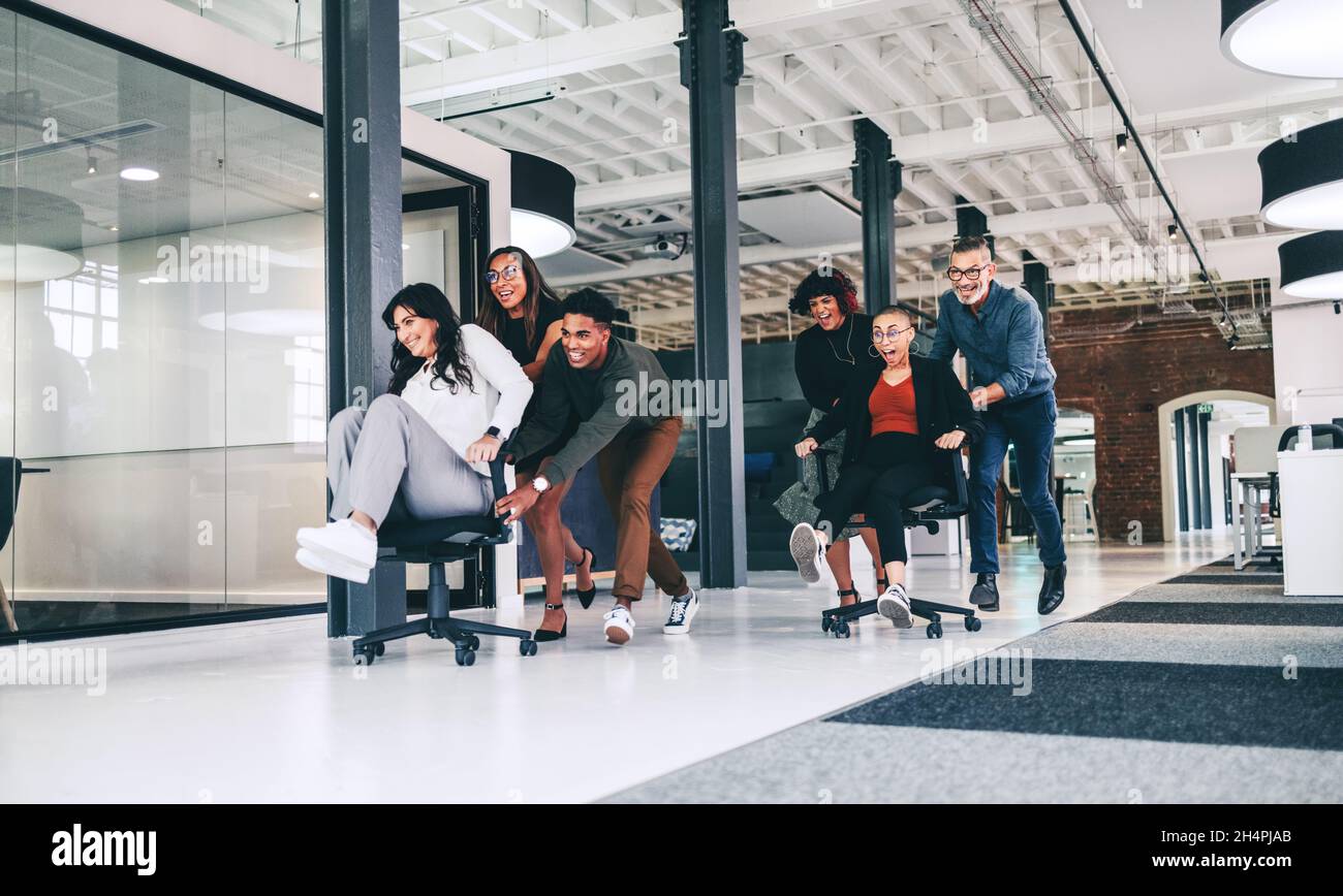 Team of businesspeople having fun together in an office. Cheerful group ...