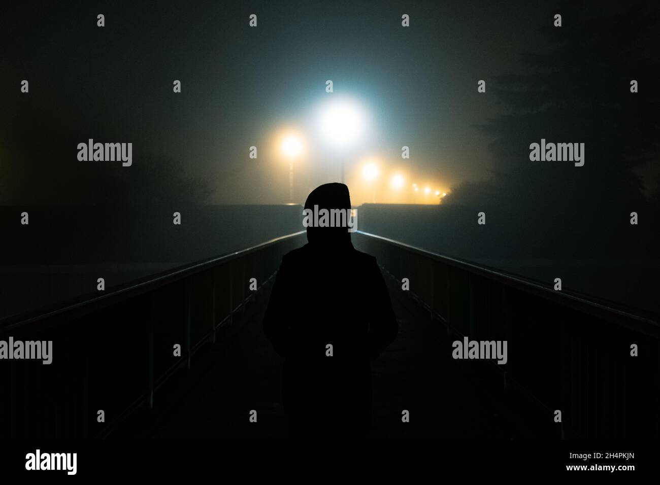 Woman walking on a bridge in the fog by night turning her back Stock ...