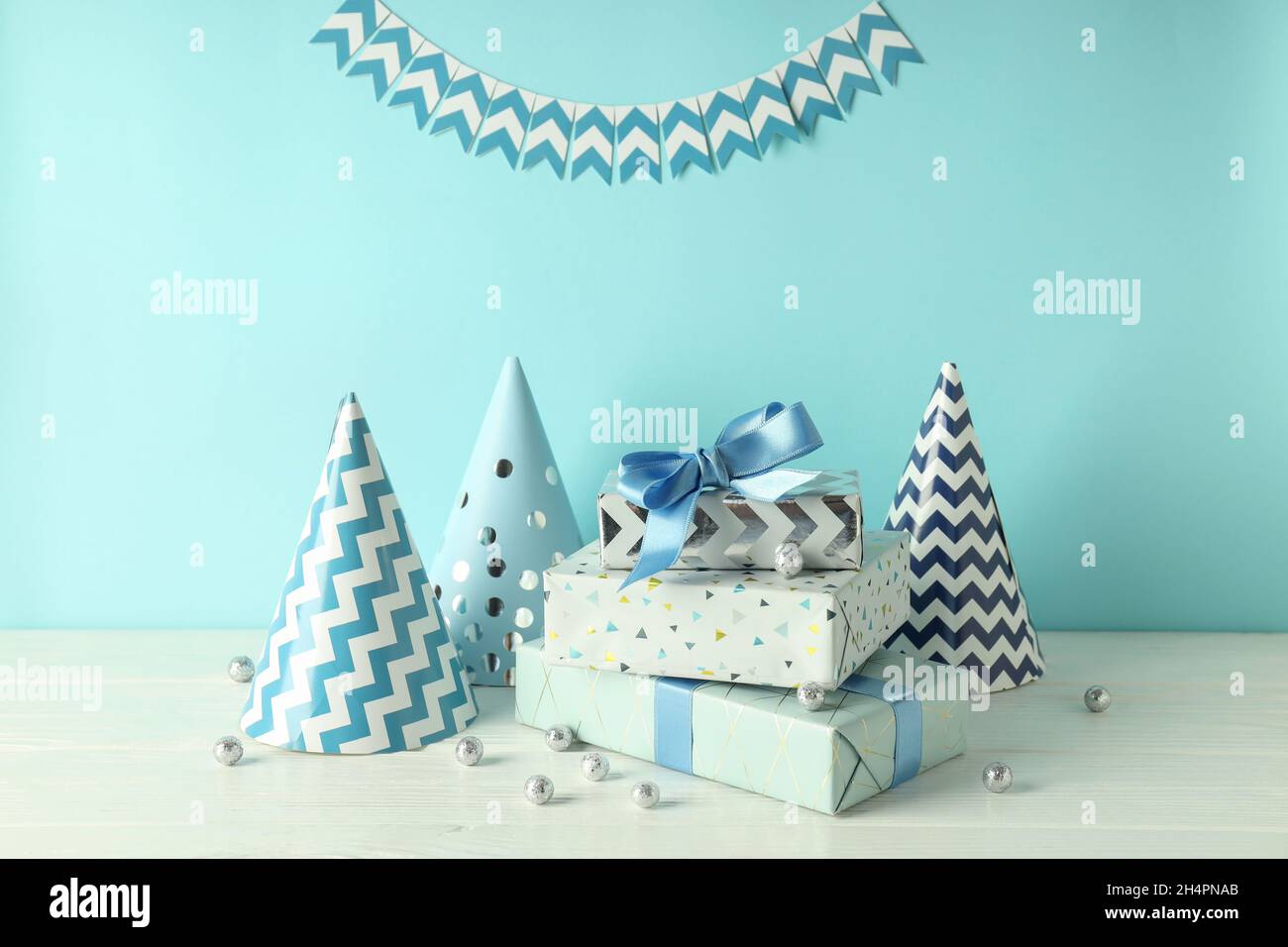 Birthday accessories on white wooden table against blue background ...