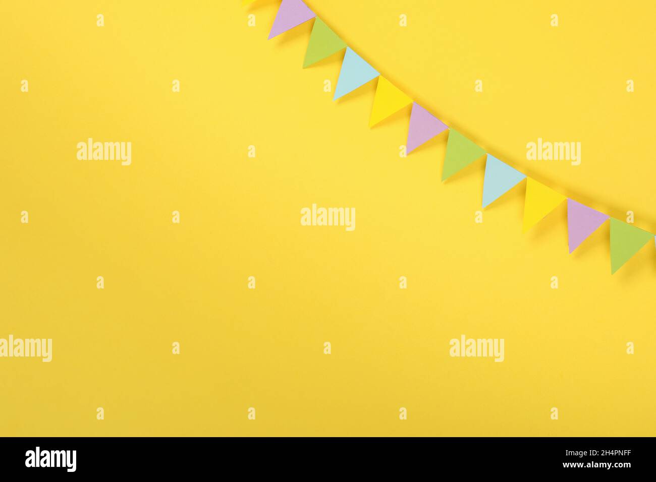 Party flags on yellow background, space for text Stock Photo - Alamy