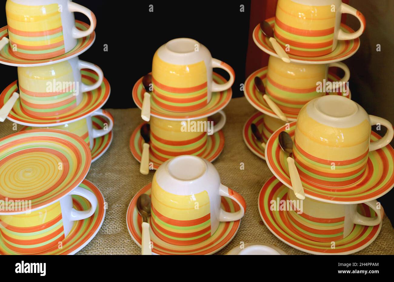 Stacks of vibrant color cups and saucers ready for break time Stock ...
