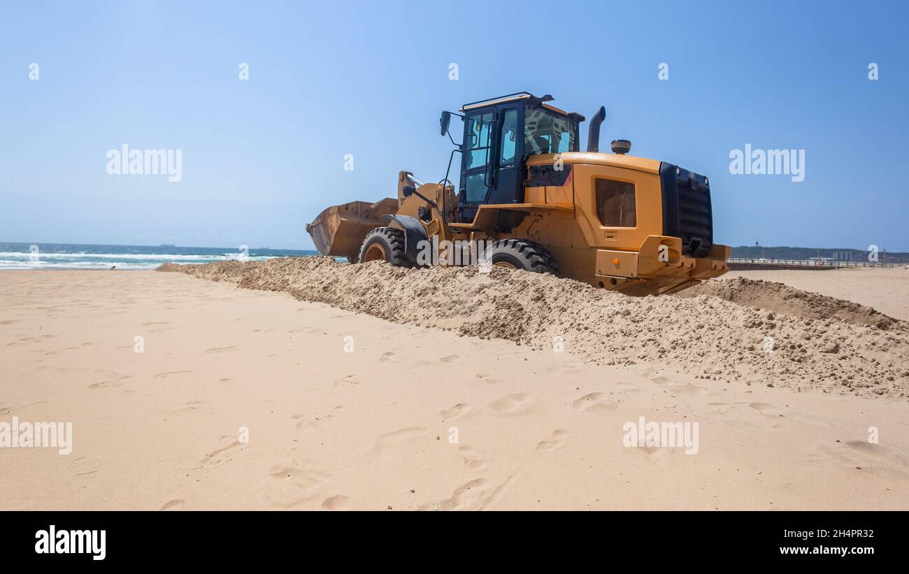 Beach landscaping moving sand by industrial tipper bulldozer machine ...