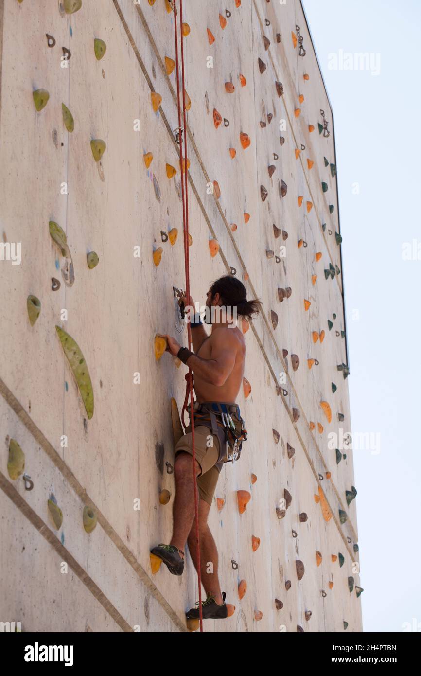 young man climbing in climbing wall, urban sport, summer, self ...
