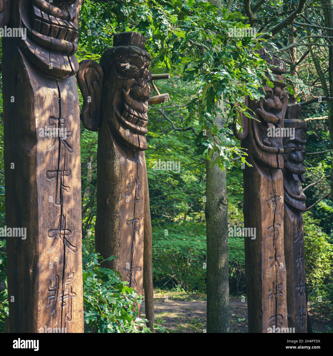 Vertical shot of wooden totems with freaky faces and Chinese ...