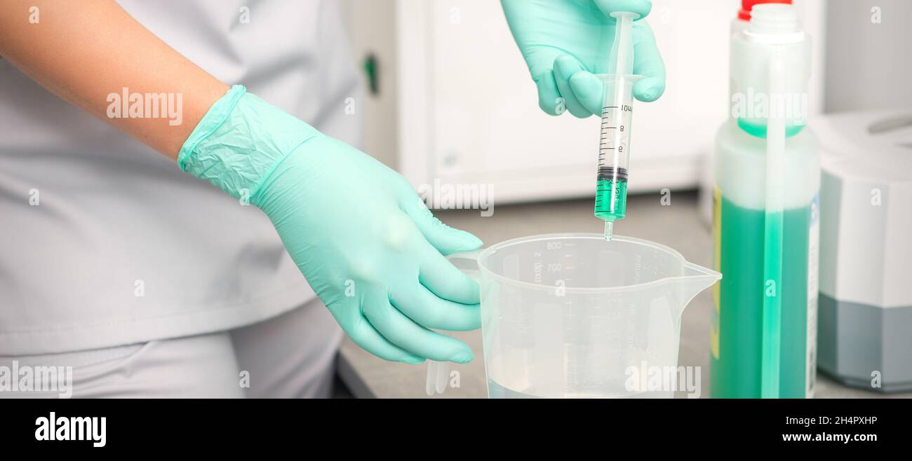 The beautician uses a syringe to add disinfectant to the water ...