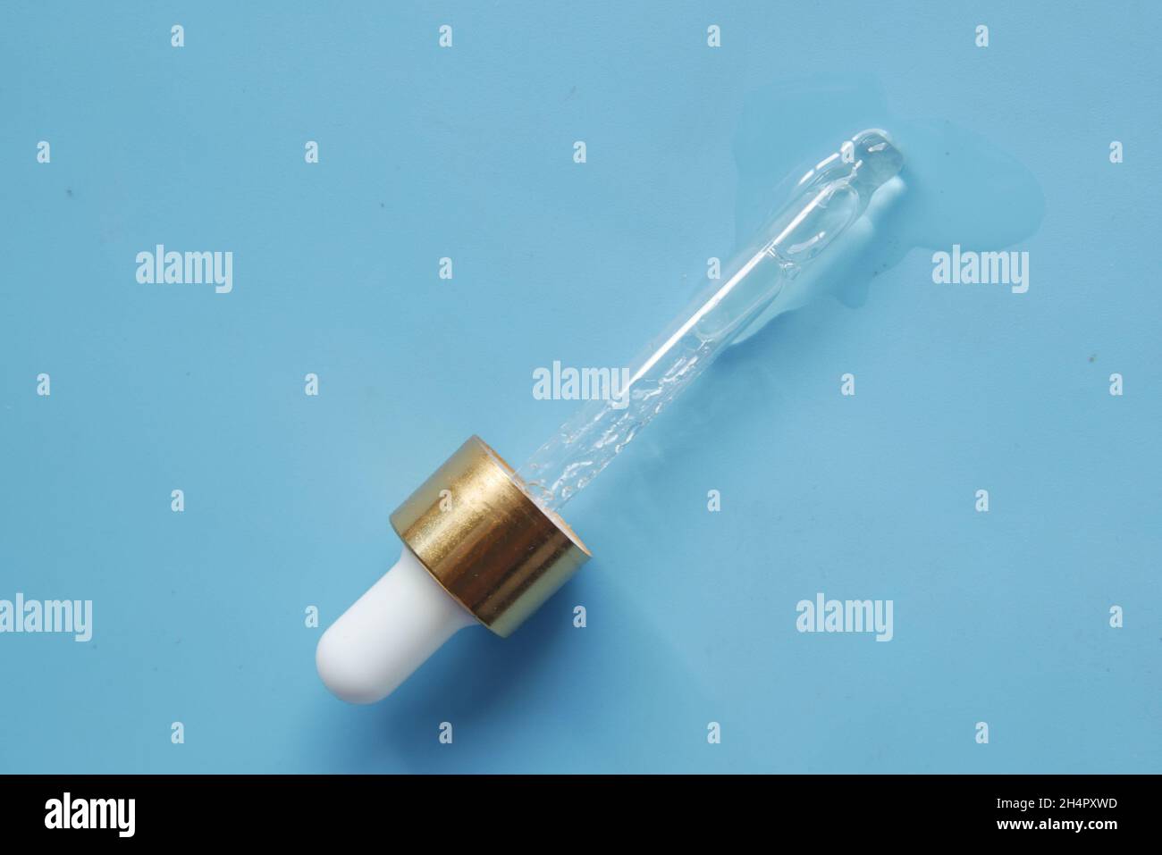 Drop falls from a pipette on blue background Stock Photo - Alamy