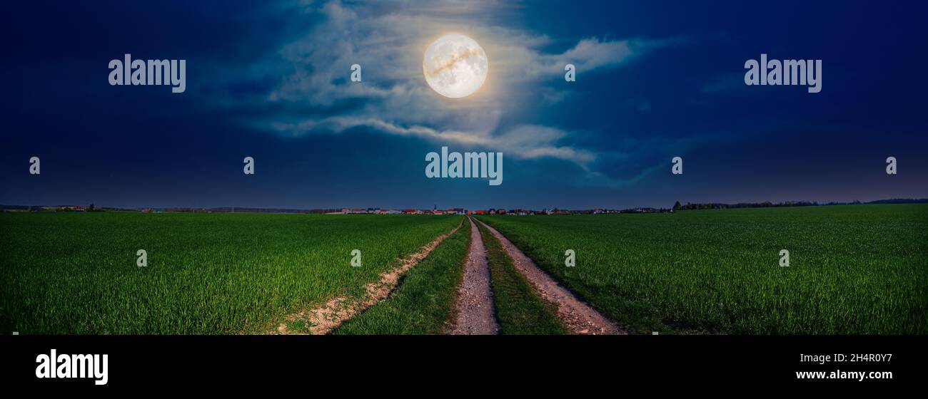 Path in a night meadow overlooking the full moon Stock Photo - Alamy