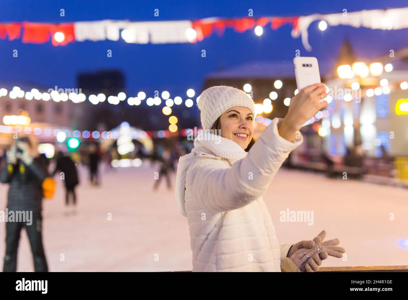 Christmas, winter, technology and leisure concept - happy young woman ...