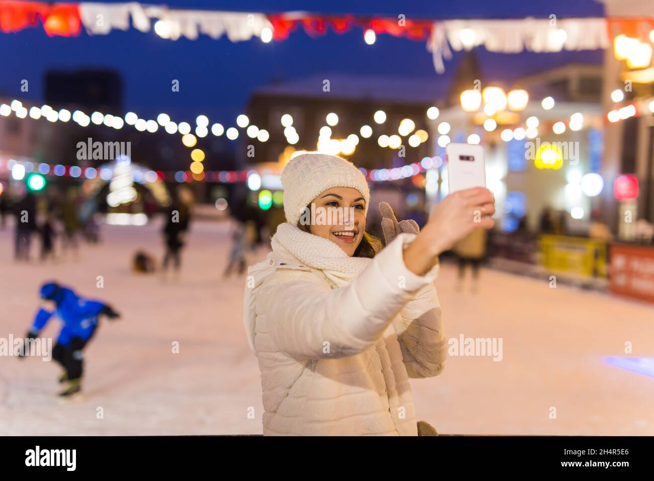 Christmas, winter, technology and leisure concept - happy young woman ...