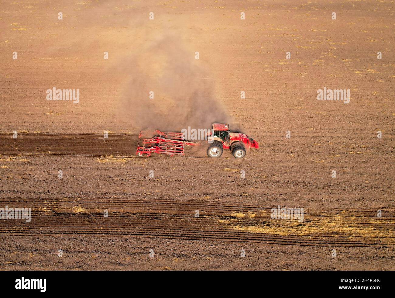 Soil Tillage in farmers country. Red Tractor on cultivating field work ...