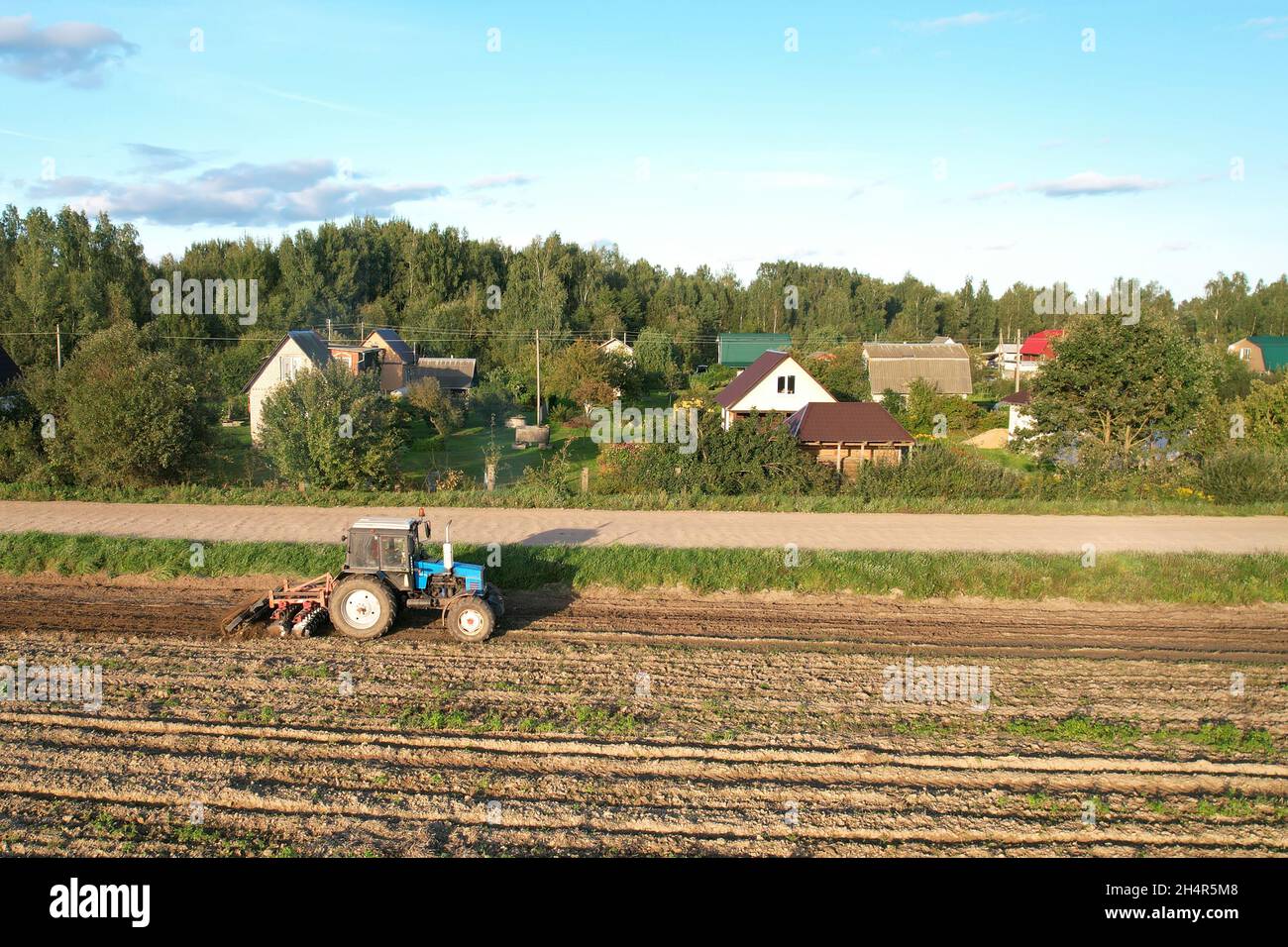 Tractor on cultivating field work. Soil Tillage in farmers country ...