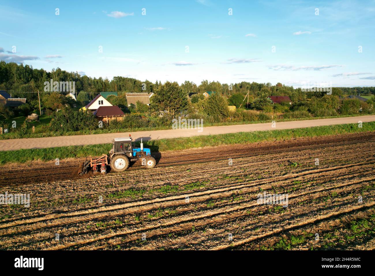 Tractor on cultivating field work. Soil Tillage in farmers country ...