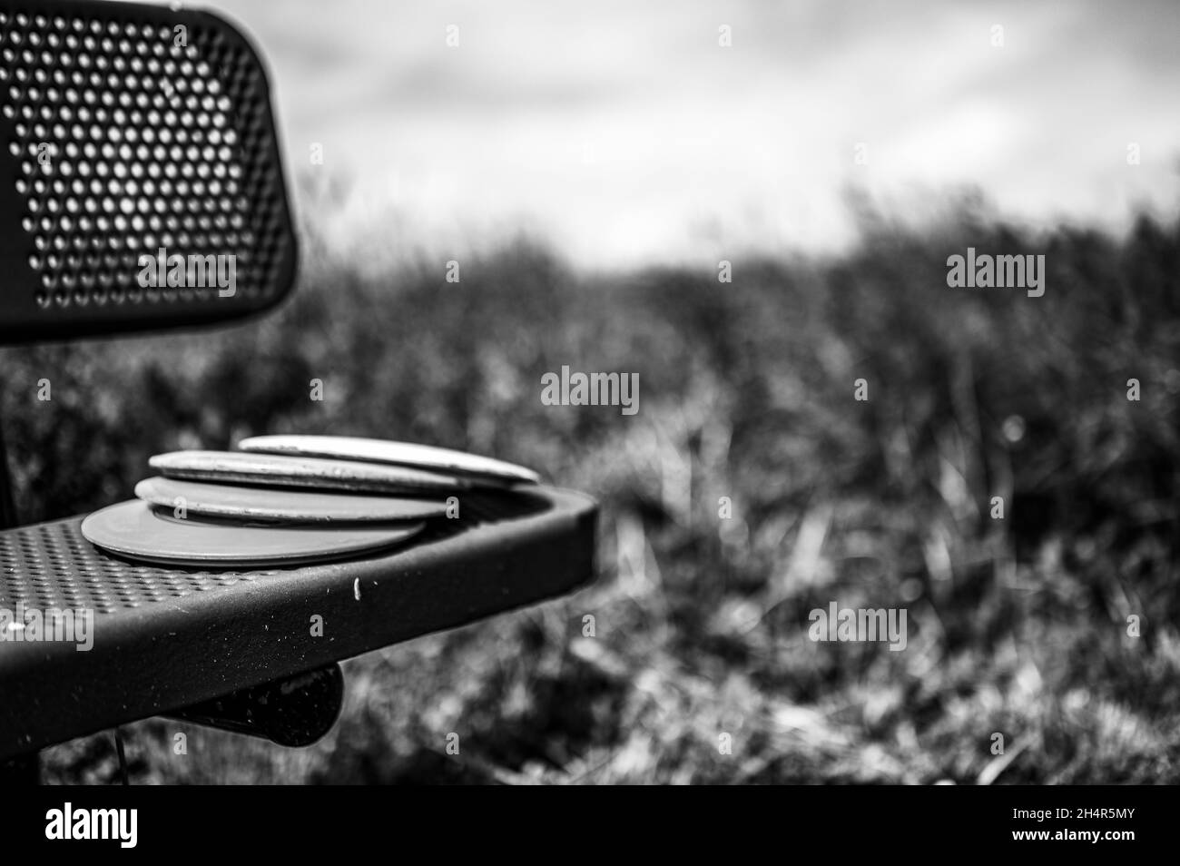 Pile of discs resting on a bench in the golf course park Stock Photo ...