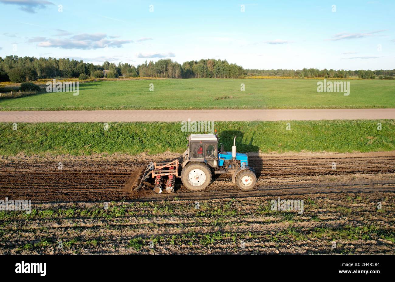 Tractor on cultivating field work. Soil Tillage in farmers country ...