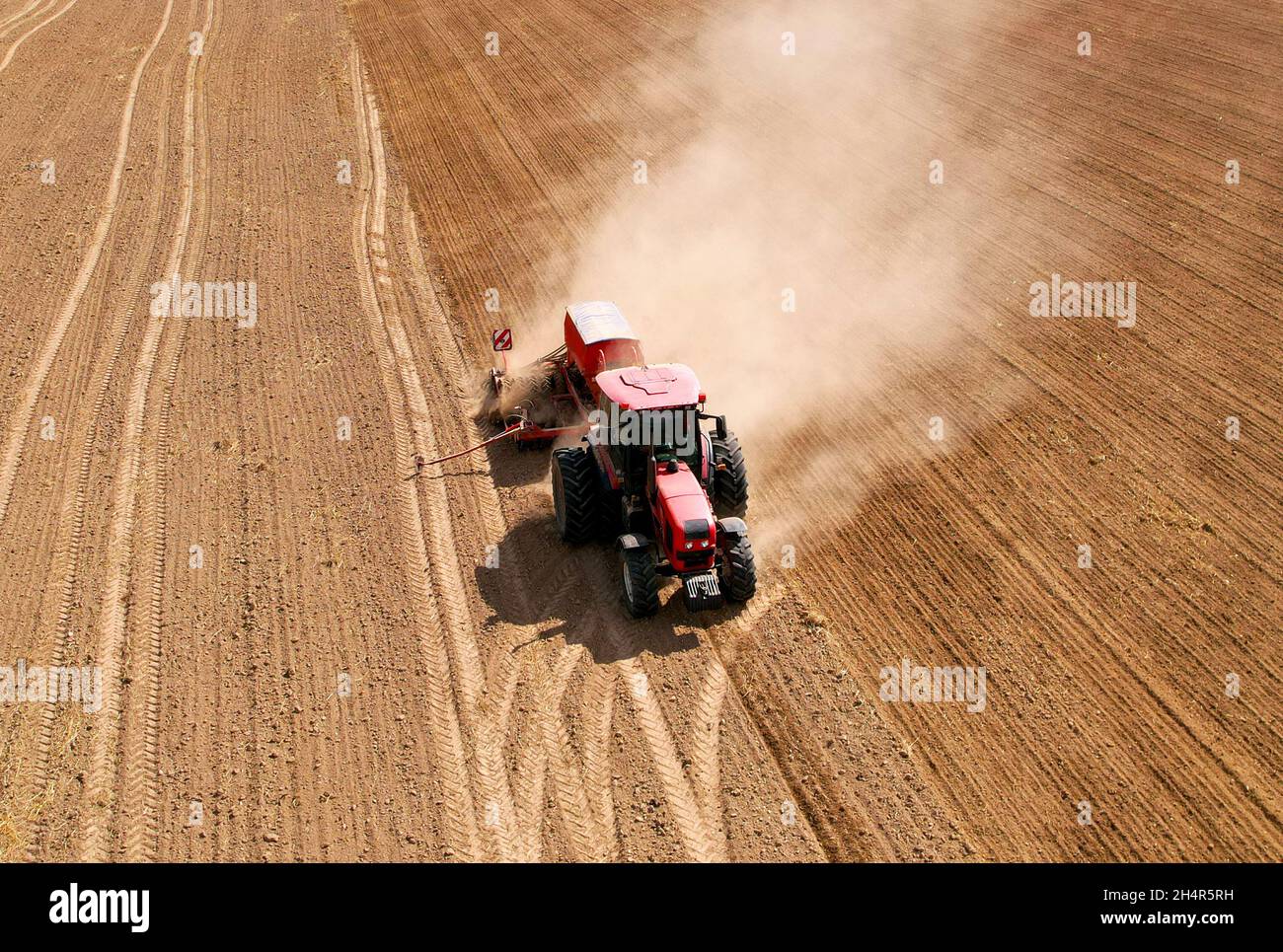 Agricultural tractor sowing seed onto at field. Farming and seeding ...