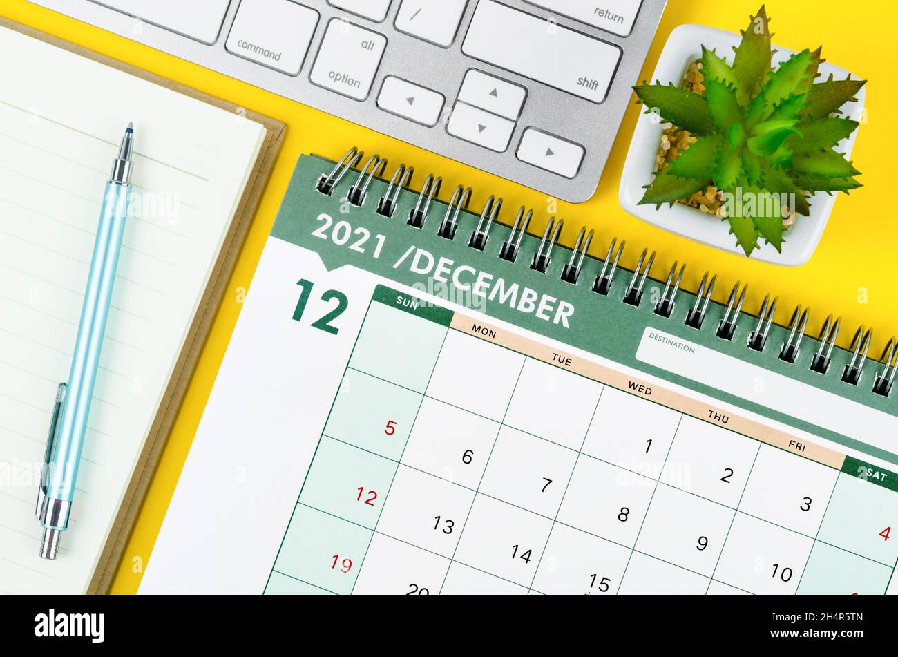 December 2021 desk calendar and diary with keyboard computer on yellow ...