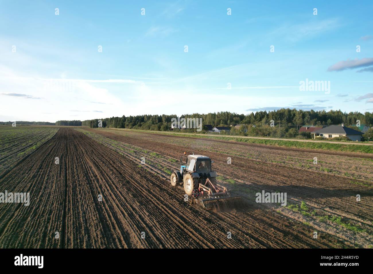 Tractor on cultivating field work. Soil Tillage in farmers country ...