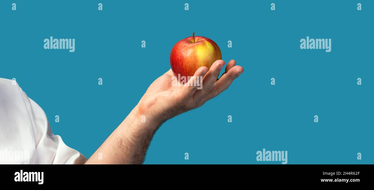 Healthy lifestyle and apple diet. Male hand with red apple on blue ...