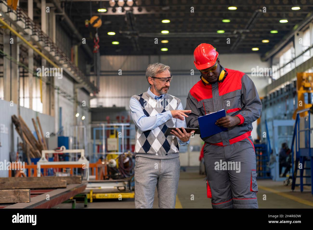 Multiracial Industrial Co-Workers Standing In A Factory And Talking ...