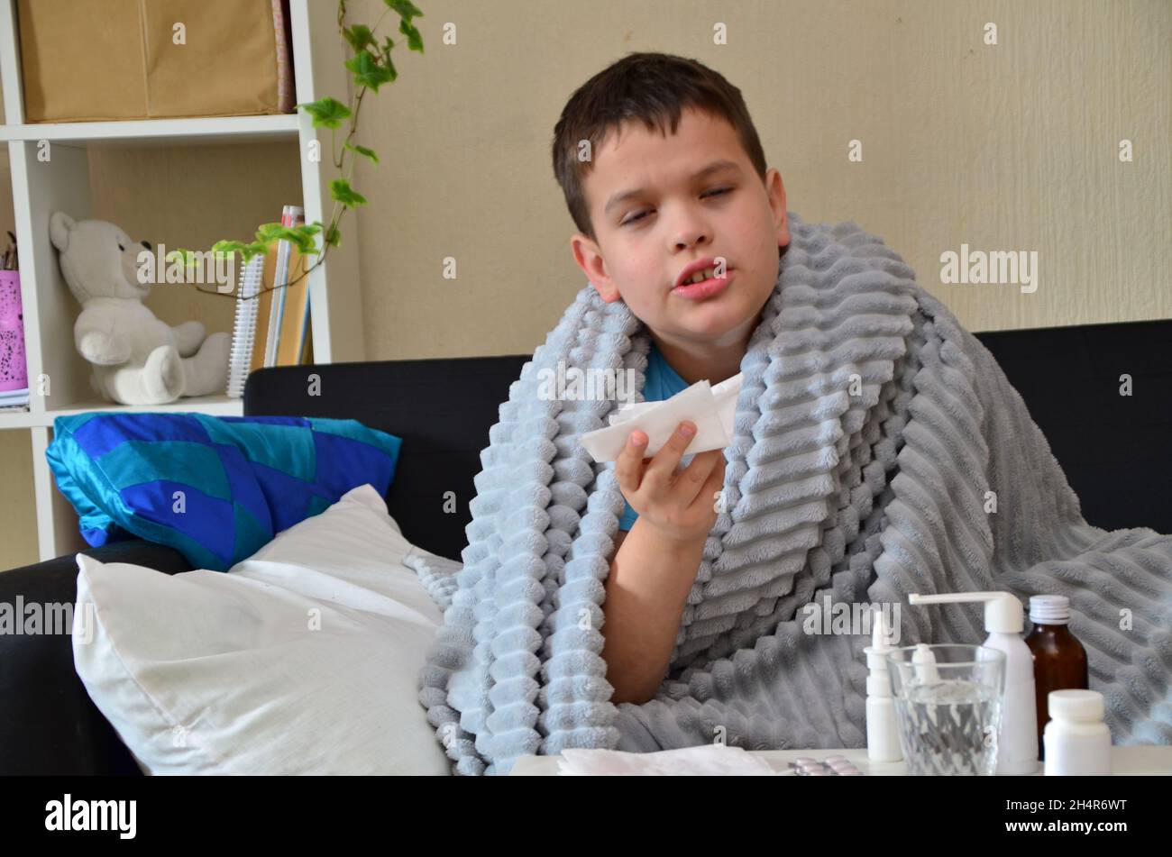 Sick child boy lying in bed with a fever, resting at home. a boy with a ...