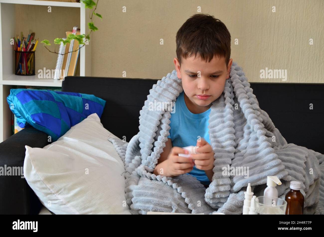Sick child boy lying in bed with a fever, resting at home. a boy with a ...