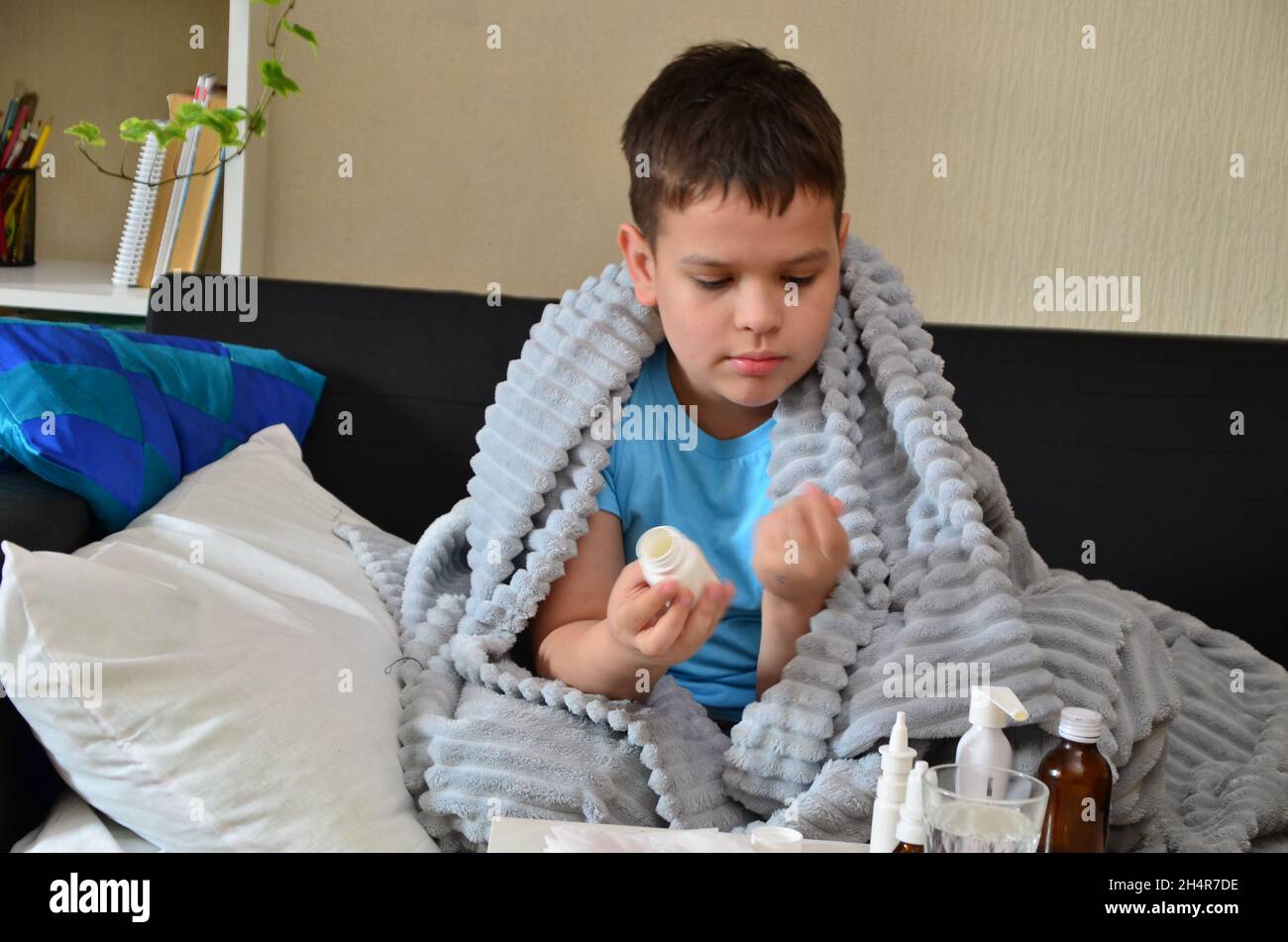 Sick child boy lying in bed with a fever, resting at home. a boy with a ...