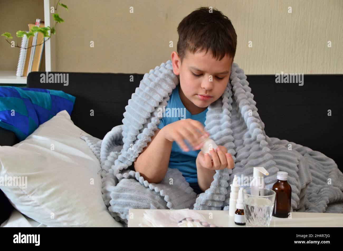 Sick child boy lying in bed with a fever, resting at home. a boy with a ...