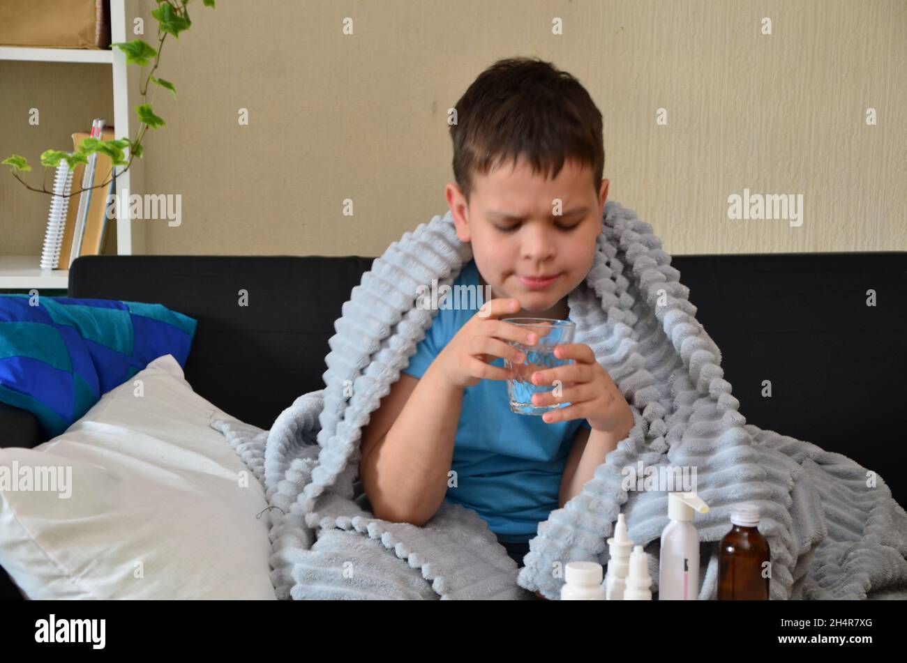 Sick child boy lying in bed with a fever, resting at home. a boy with a ...