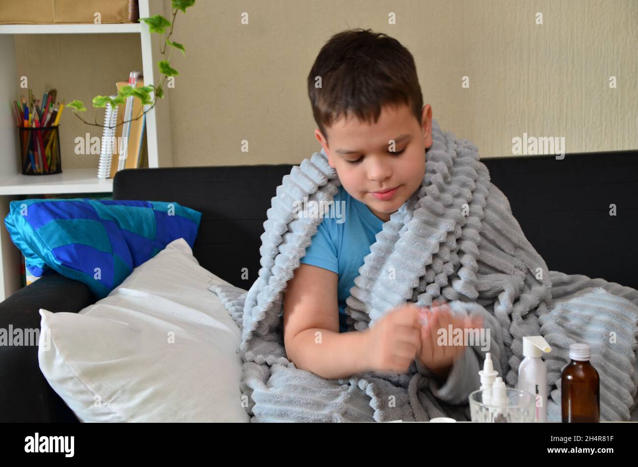 Sick child boy lying in bed with a fever, resting at home. a boy with a ...
