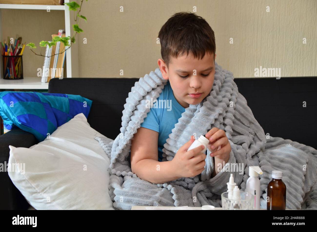 Sick child boy lying in bed with a fever, resting at home. a boy with a ...