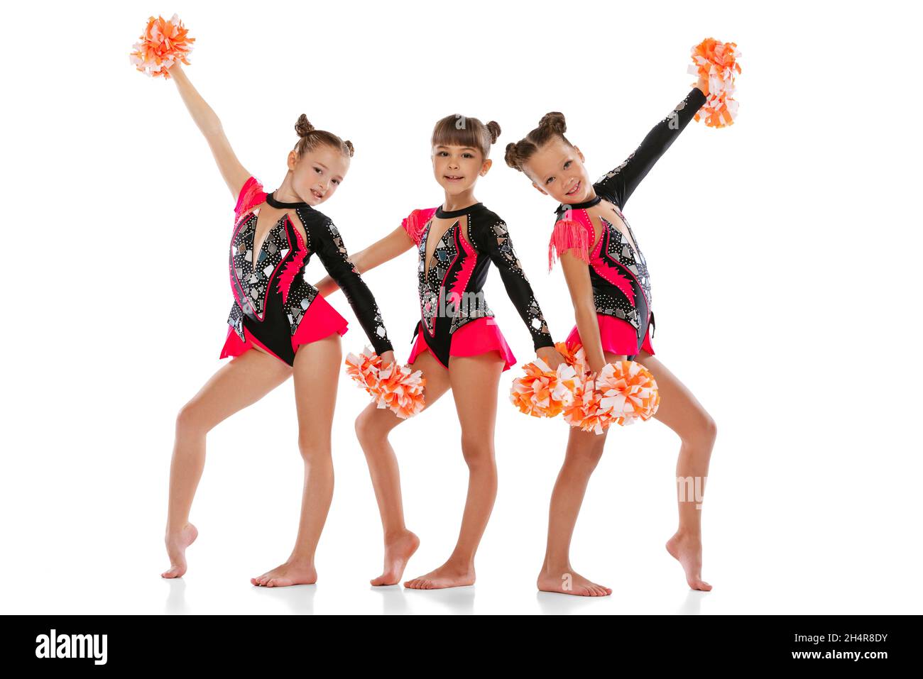 Full-length portrait of three girls, cheerleaders training isolated ...