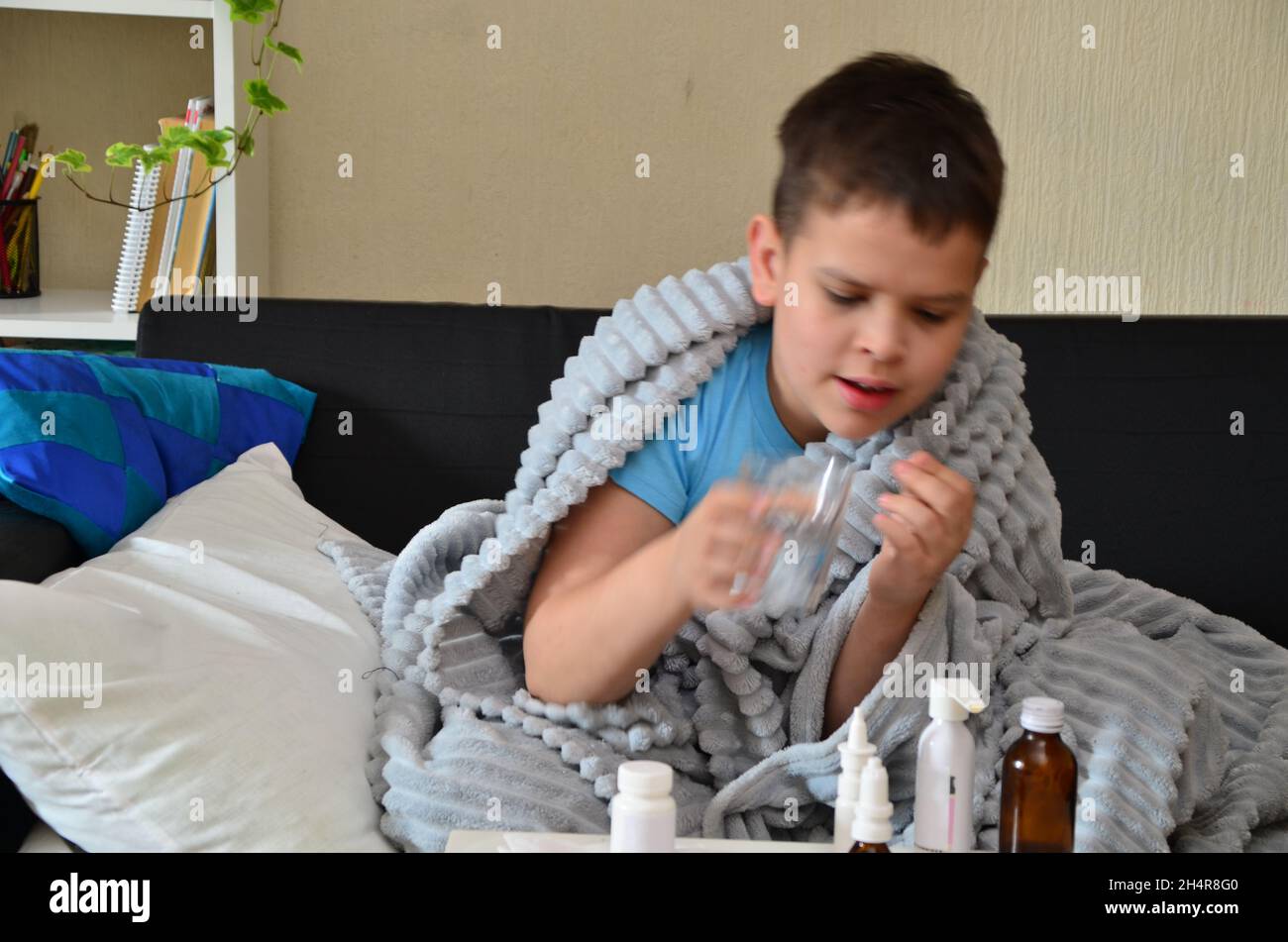 Sick child boy lying in bed with a fever, resting at home. a boy with a ...
