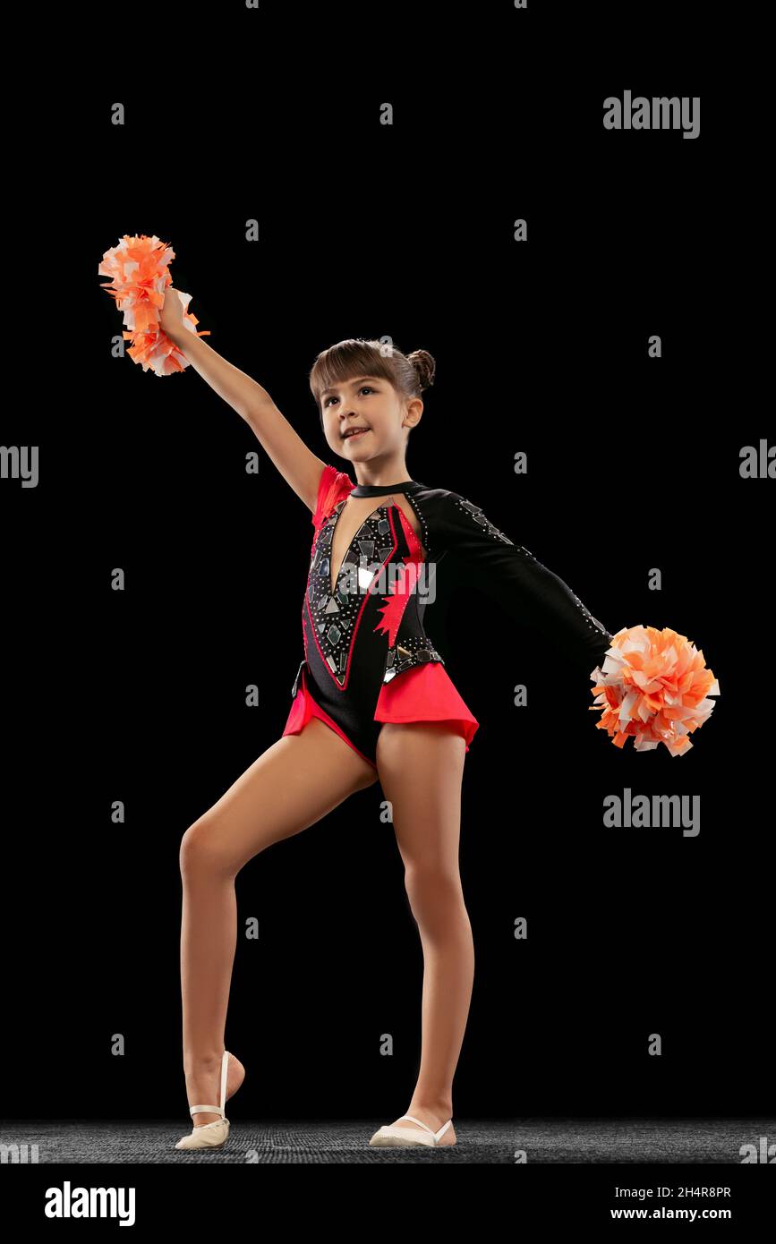 Full Length Portrait Of Beautiful Girl Cheerleader Training Isolated Over Black Background