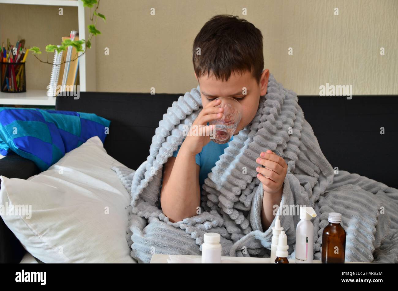 Sick child boy lying in bed with a fever, resting at home. a boy with a ...